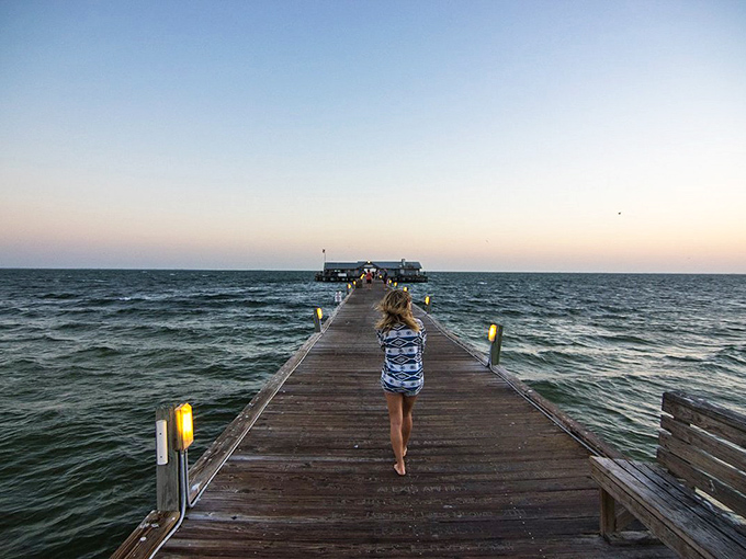 The wooden pier stretches toward the horizon, a runway for barefoot dreamers seeking that perfect sunset moment over the Gulf.