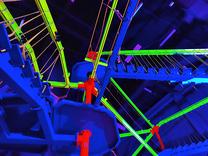 Neon-lit challenges await brave souls on this indoor ropes course, where balance meets bravery three stories above solid ground.