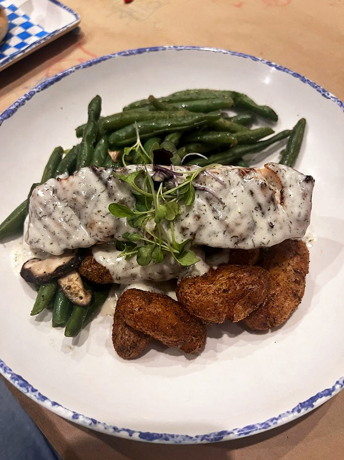 Perfectly grilled salmon resting on fingerling potatoes with green beans &ndash; proof that simple preparation lets quality shine.