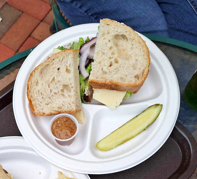 Simple perfection: crispy schnitzel nestled between fresh bread with crisp lettuce, onion, and a pickle that's not just there for decoration.