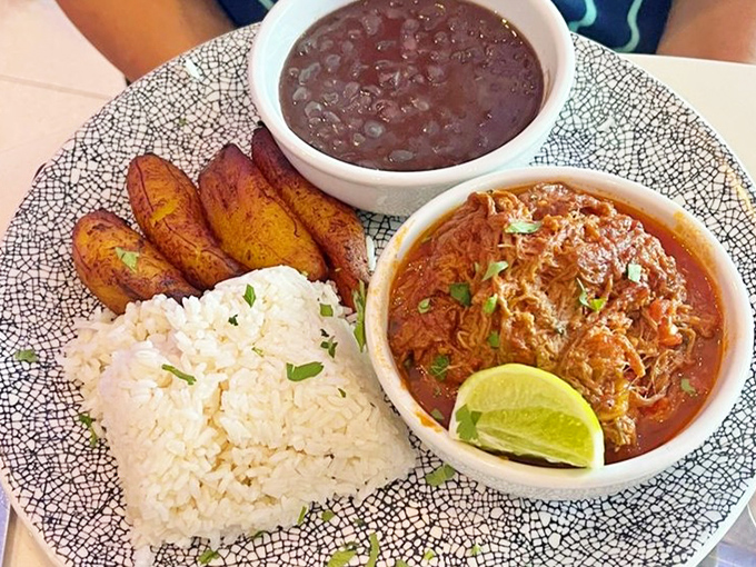 Cuban-style shredded beef arrives with the kind of tenderness that only comes from patience &ndash; served with rice, beans, and plantains that transport you to Havana.