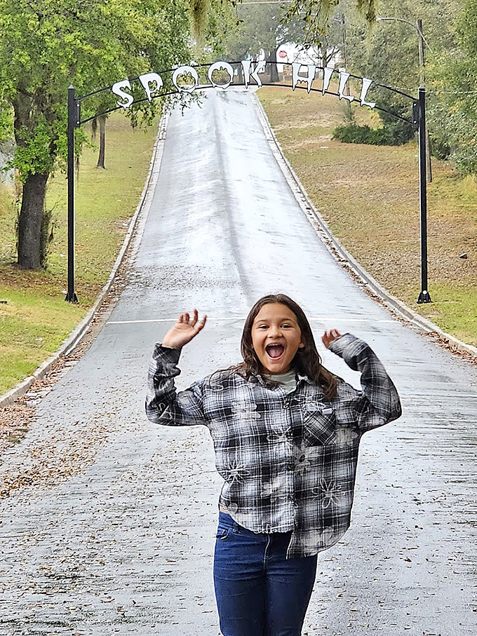 Pure joy captured at Spook Hill's entrance &ndash; the perfect spot for creating family memories filled with wonder, laughter, and a touch of mystery.