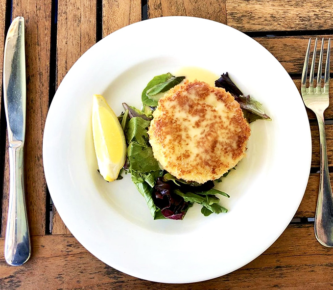 Crab cake meal: Two golden discs of crabby heaven with a side of greens &ndash; simplicity that lets the star ingredient shine.