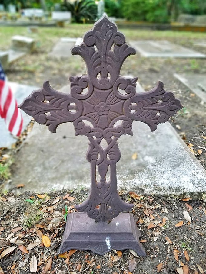Intricate ironwork showcases the craftsmanship of another era, this ornate cross telling its own silent story of faith and remembrance.