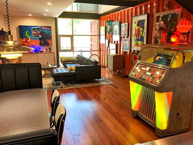 The dining room waits eternally for guests, its wooden walls glowing amber in the lamplight, ready for conversations that lasted hours, not characters.