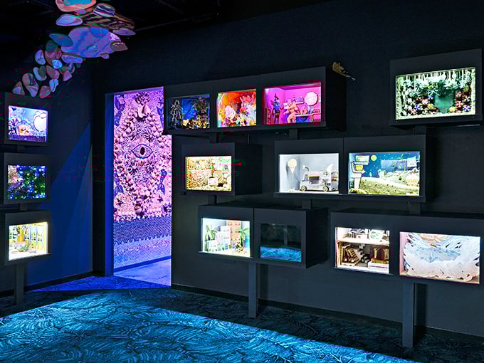 Illuminated dioramas line the walls like windows into parallel universes, each one a miniature world waiting to be discovered.