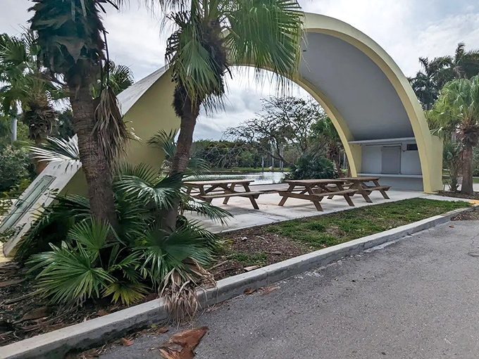 Picnic tables now occupy spaces where families once gathered to view exotic animals, offering a surreal dining experience amid historical remnants.
