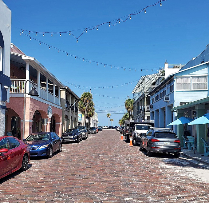 Brick-paved streets and string lights create the perfect ambiance for evening strolls through Pass-A-Grille's charming commercial district.