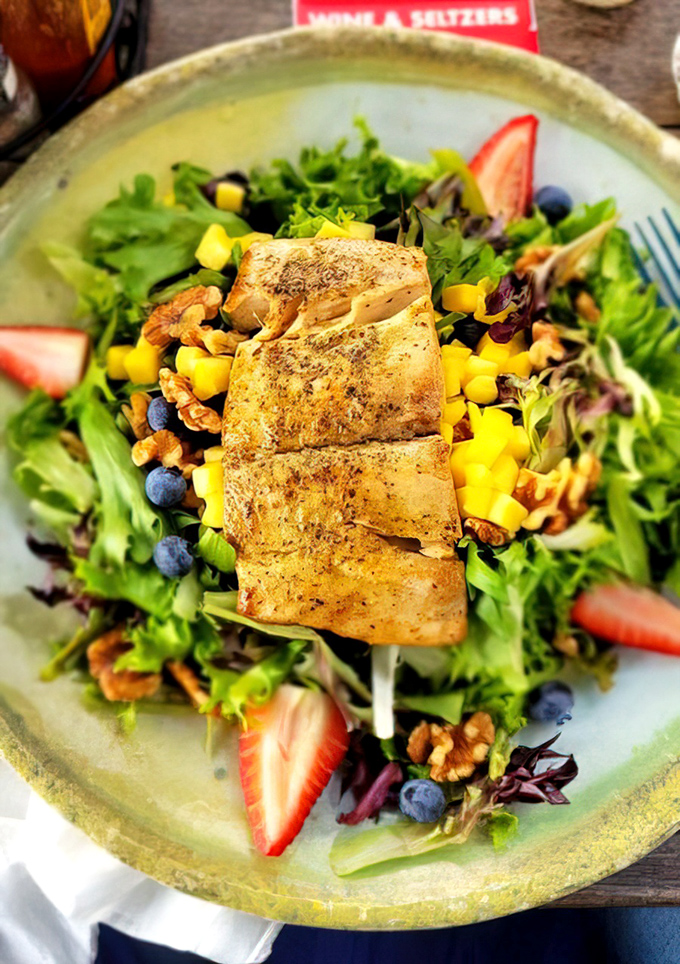 Fresh mixed greens, candied walnuts, and seasonal fruit create the perfect backdrop for the blackened mahi-mahi, drizzled with house-made honey mustard.