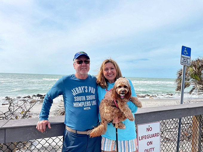Happy visitors and their furry friend soak up the Gulf Coast sunshine, proving paradise is best when shared with loved ones.