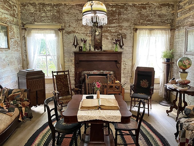 The parlor's weathered walls and period furnishings tell stories of family gatherings where conversation, not screens, provided the evening entertainment.