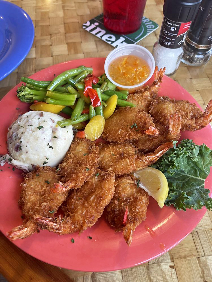Holy Mackerel! Crispy, golden coconut shrimp, served with fluffy mashed potatoes and vibrant veggies. A truly tropical delight!