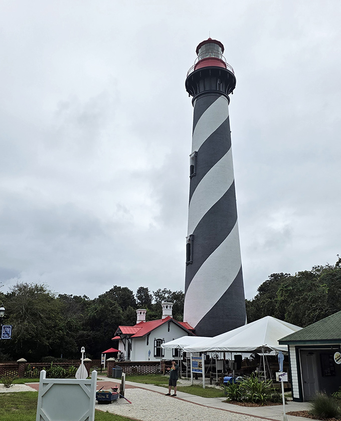 Another Angle: The lighthouse stands sentinel against cloudy skies, its distinctive stripes a warning to ships and an invitation to curious travelers.