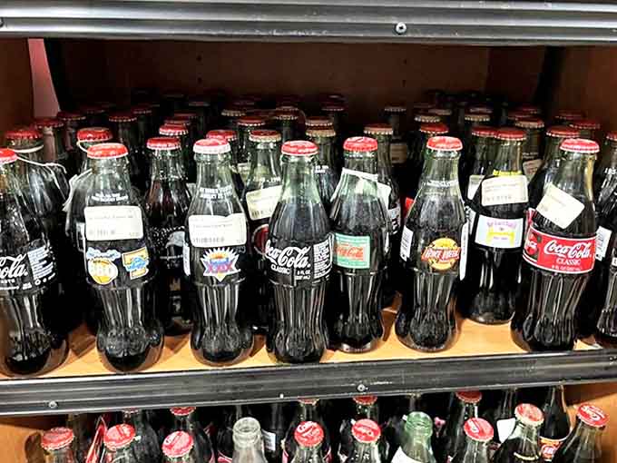 Coca-Cola bottles stand in formation like tiny glass soldiers, each special edition label telling stories of promotions long forgotten.
