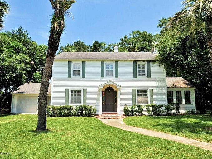 This colonial-style home stands proudly among the oaks, its classic architecture complementing the natural grandeur surrounding it.