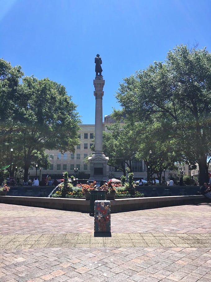 A stately monument stands sentinel in the park's center, surrounded by flowers and history, a reminder of Jacksonville's rich past.
