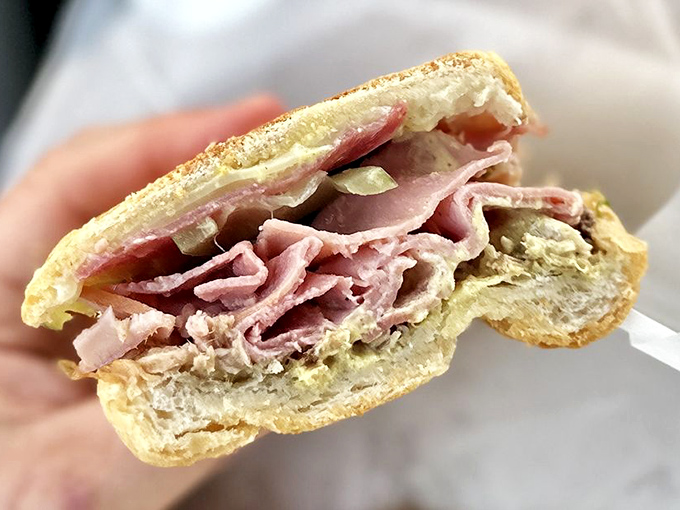 Tender layers of marinated pork create the heart of this sandwich, a testament to simple ingredients done right.