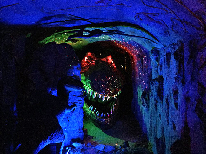 The T-Rex's jaws glow menacingly in the cave's otherworldly lighting, creating the perfect blend of cheesy fun and genuine "maybe we should walk faster" moments.