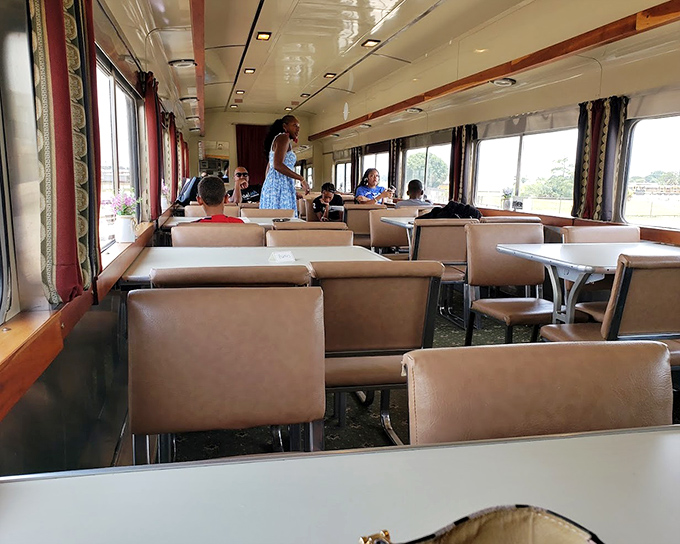 Fellow travelers enjoy the refined atmosphere of the First Class Table Car, where conversation flows as smoothly as the scenery.
