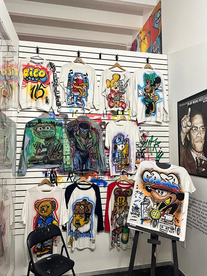 Graffiti Apparel Display Wall: Wearable canvases hang like trophies of urban expression, proving that sometimes the most exciting fashion shows happen on city streets, not runways.