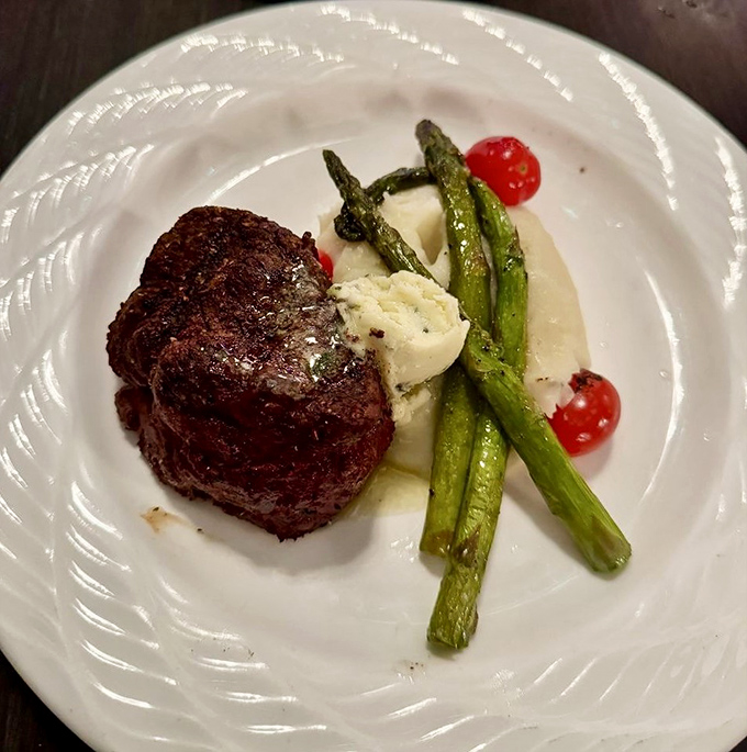 The grilled filet mignon arrives cooked to perfection, accompanied by asparagus spears standing at attention like the castle guard.