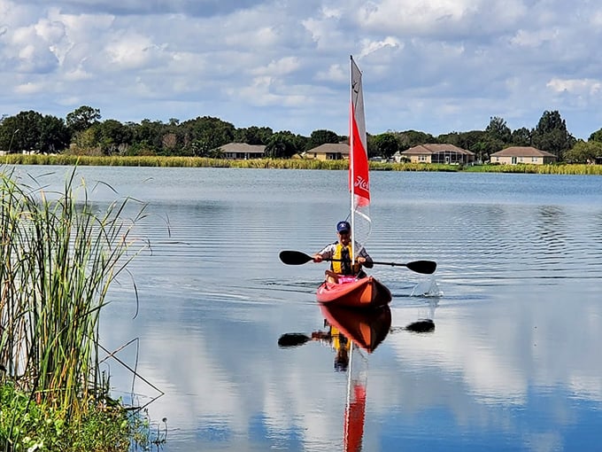 A peaceful paddler glides across Secret Lake's surface, creating barely a ripple&mdash;the definition of "social distancing" before it was trendy.