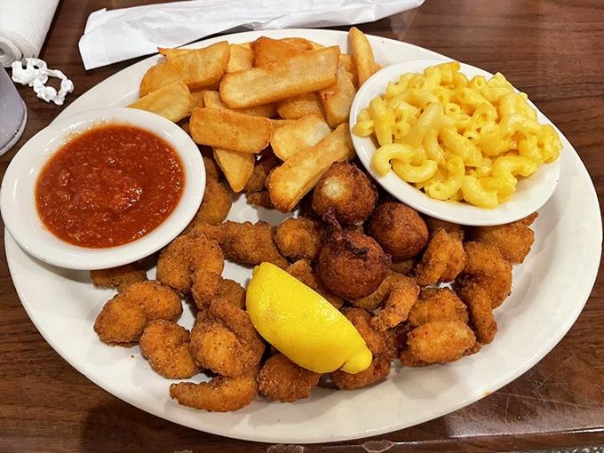 Golden-fried popcorn shrimp nestled beside steak fries and mac & cheese &ndash; comfort food that hugs your soul.