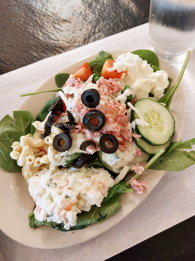 Fresh greens topped with cottage cheese, olives, and vegetables create a refreshing counterpoint to the heartier offerings on the buffet line.