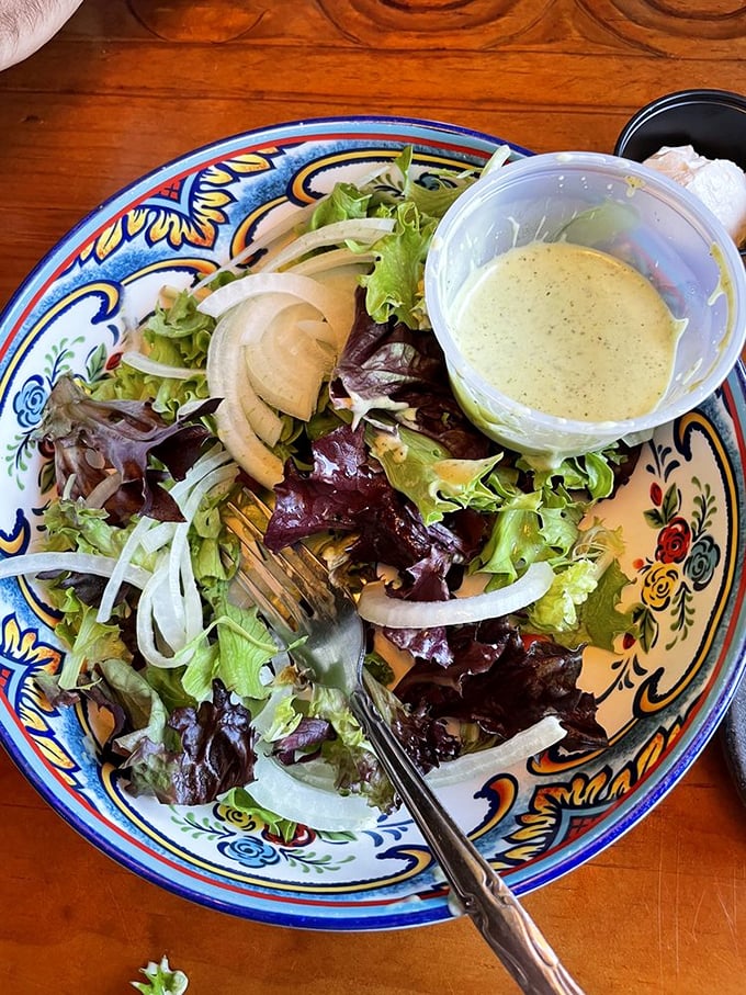 Even the salad gets special treatment&mdash;crisp greens, thinly sliced onions, and house-made dressing served on a decorative plate.