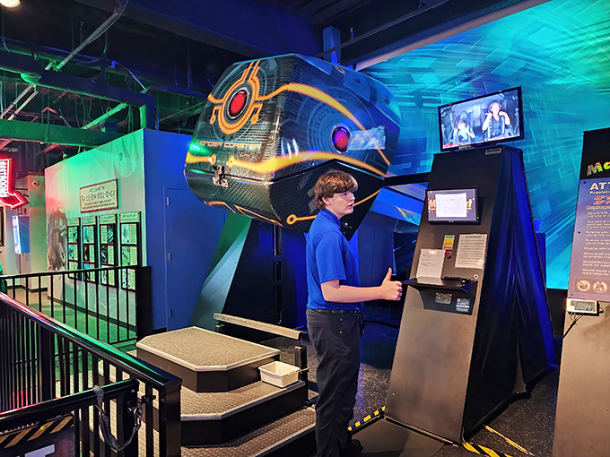 A helpful team member gives the thumbs up at one of WonderWorks' high-tech attractions, ready to guide visitors through their scientific adventure.