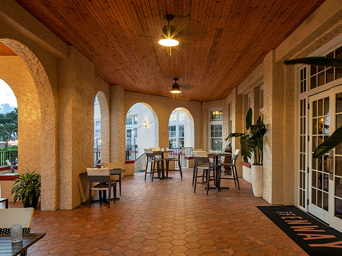The veranda offers shaded outdoor seating under a wooden ceiling, where Gulf breezes carry conversations into the evening.