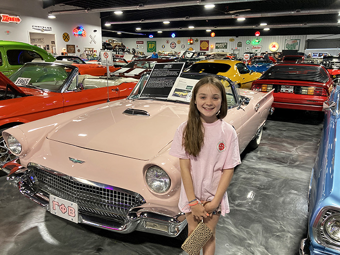 Nothing says "childhood dream" like standing next to a pink Thunderbird that matches your shirt &ndash; pure automotive magic captured.