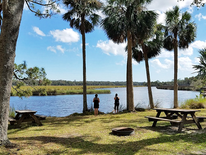 Two visitors contemplate the serene waters, proving that sometimes the best vacation activity is simply standing still and breathing.