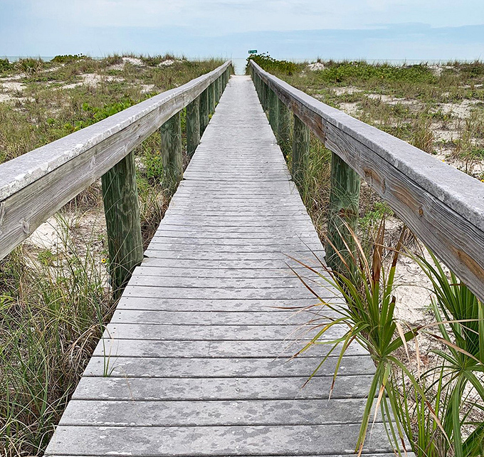 This wooden boardwalk invites exploration, leading beach-goers through protected dunes to the Gulf's sparkling waters.