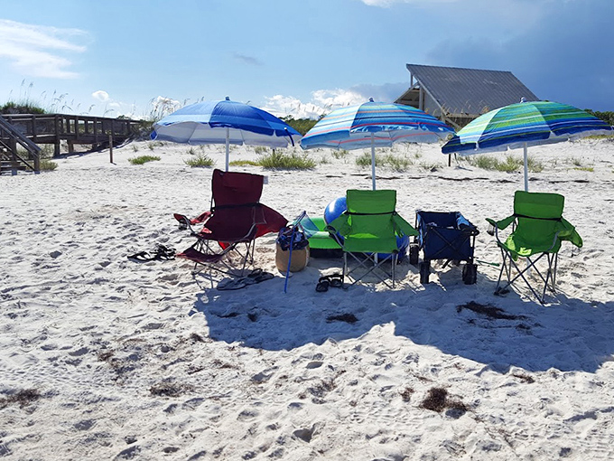 Beach day essentials: Colorful chairs and umbrellas dot the sugar-white sand, creating personal oases for sun-seekers.