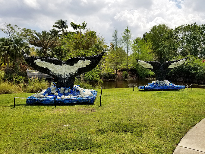 These majestic whale tails breach from a sea of blue recycled materials, turning environmental awareness into an artistic statement.