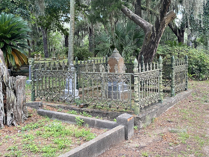 Victorian-era craftsmanship on display in this elaborate iron enclosure, green patina speaking to decades of Florida's humid embrace.