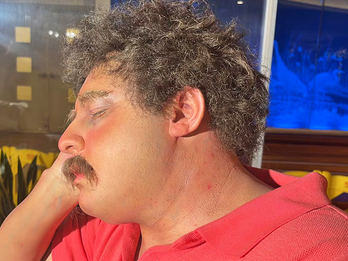 That perfectly disheveled hair and mustache combo &ndash; the hallmark of a traveler who's given up on appearances after the third layover.