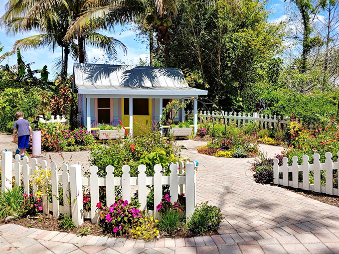 This charming cottage surrounded by a white picket fence and vibrant blooms looks straight out of a storybook.