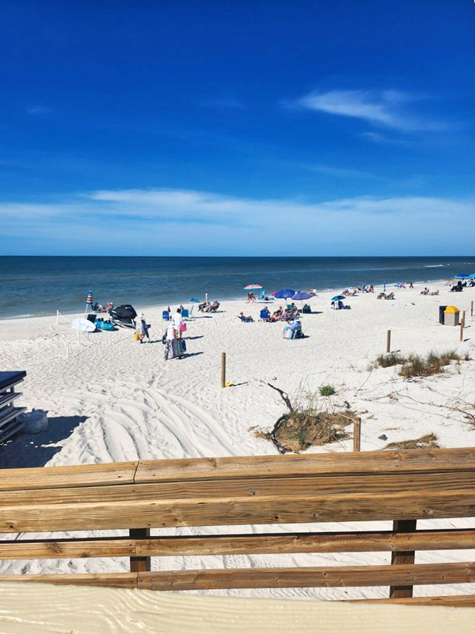 Beach-goers dot the shoreline with colorful umbrellas, creating a classic Florida scene where the Gulf's turquoise waters meet powdery white sand.