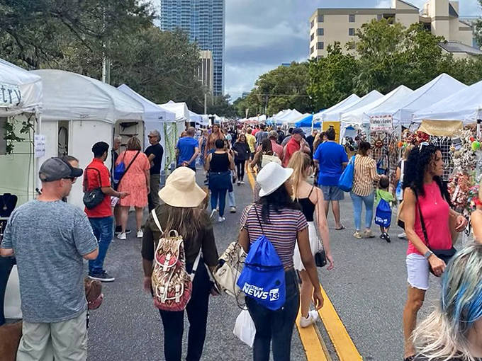 Crowds stroll through white-tented booths at Orlando's Spring Fiesta in the Park, a treasure hunt of art and handcrafts beneath the city skyline.