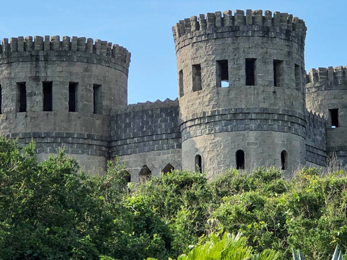 The castle's imposing stone fa&ccedil;ade features twin towers and a central entrance, creating a striking tribute to ancient Irish Christian architecture.