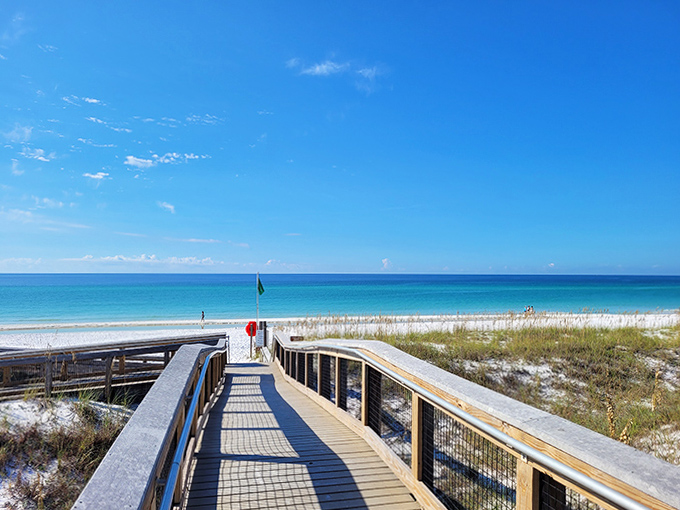 The wooden boardwalk at Henderson Beach State Park leads visitors through natural dunes to the stunning white sands and clear waters beyond.