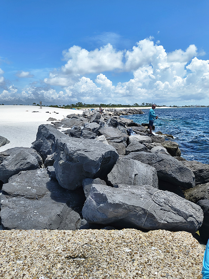 The rock jetty serves as both natural breakwater and impromptu gathering spot for those seeking the perfect fishing perch or sunset view.