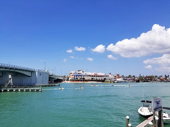 Jet skiers carve paths through turquoise waters while the bridge stands sentinel over Treasure Island's aquatic playground.