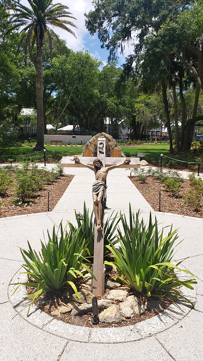 This crucifix, surrounded by Florida's native plants, creates a striking juxtaposition of ancient symbolism against the backdrop of tropical greenery.