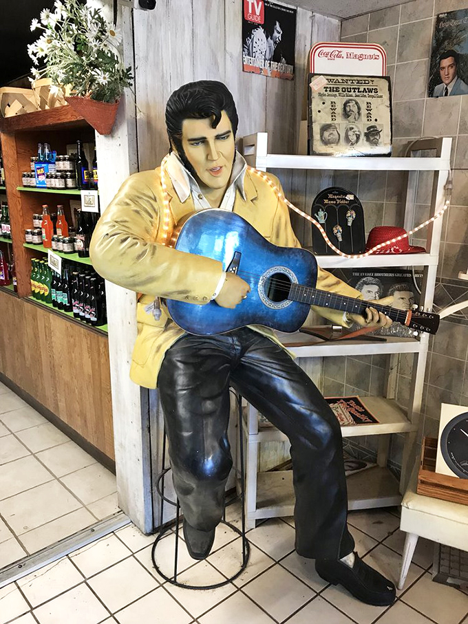 The King lives on at Boyett's, where this Elvis statue strums eternally, surrounded by vintage memorabilia and what appears to be a fully-stocked drink shelf.