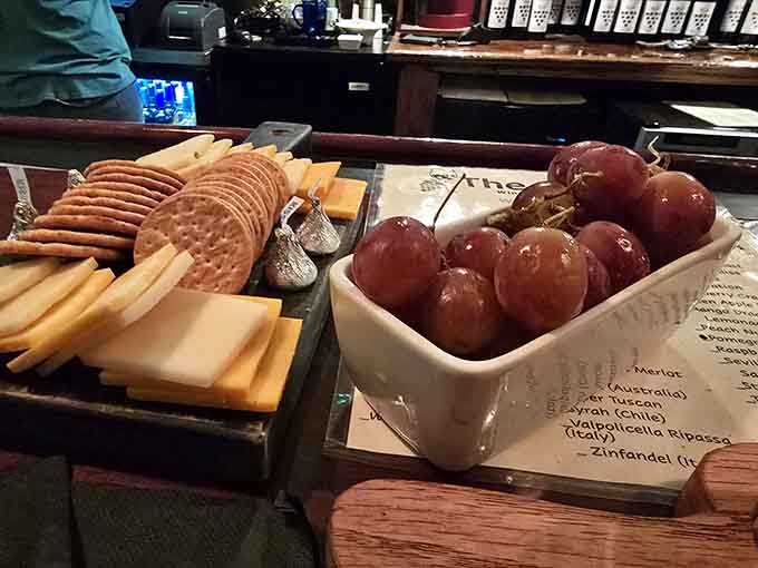 Cheese, crackers, and grapes arranged like edible art, because wine tastes even better with proper accompaniment and good company.