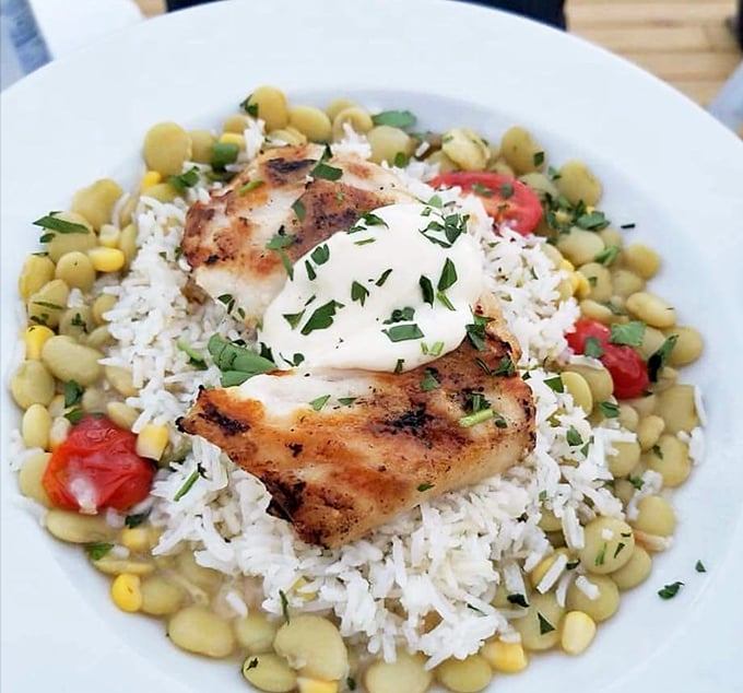 Grilled Fish Fillet: Perfectly cooked fish nestled on a bed of rice and beans &ndash; proof that sometimes the simplest preparations yield the most spectacular results.