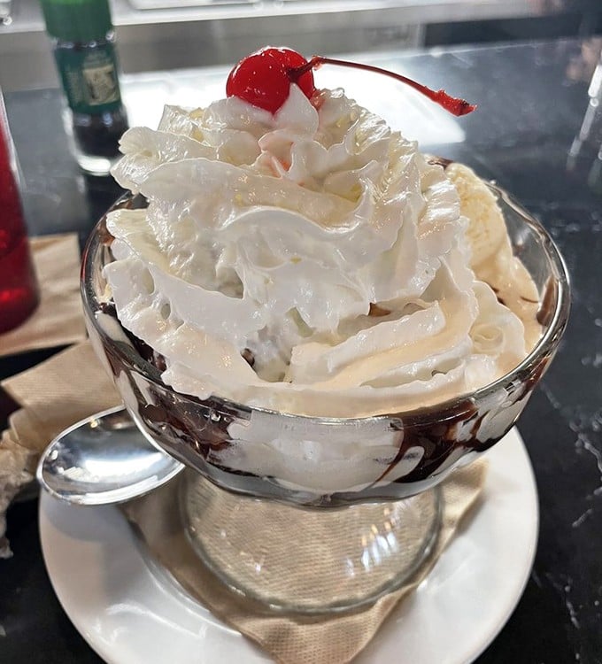 The hot fudge sundae arrives like a cloud of whipped cream perfection, crowned with that essential cherry &ndash; some traditions simply cannot be improved upon.